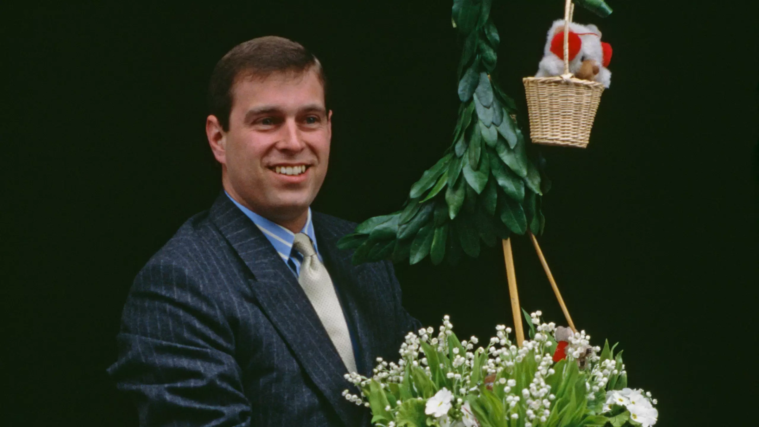 Prince Andrew poses with a gift basket for the birth of his daughter Eugenia in March 1990 at the gates of the...
