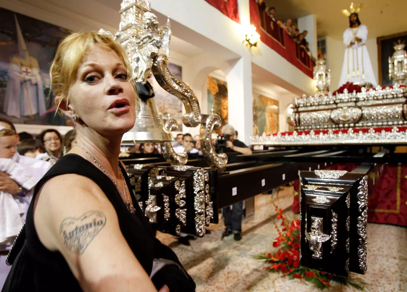 Melanie Griffith prenante memfoton apud la bildo de Jesús Cautivo en 2011.