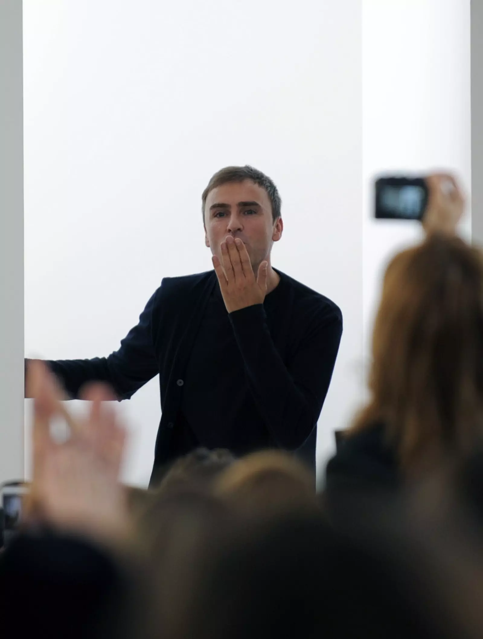 Raf Simons në vitin 2010 përshëndet audiencën e tij në fund të shfaqjes së veshjeve të gatshme pranverë-verë 2011 të Jil Sander.