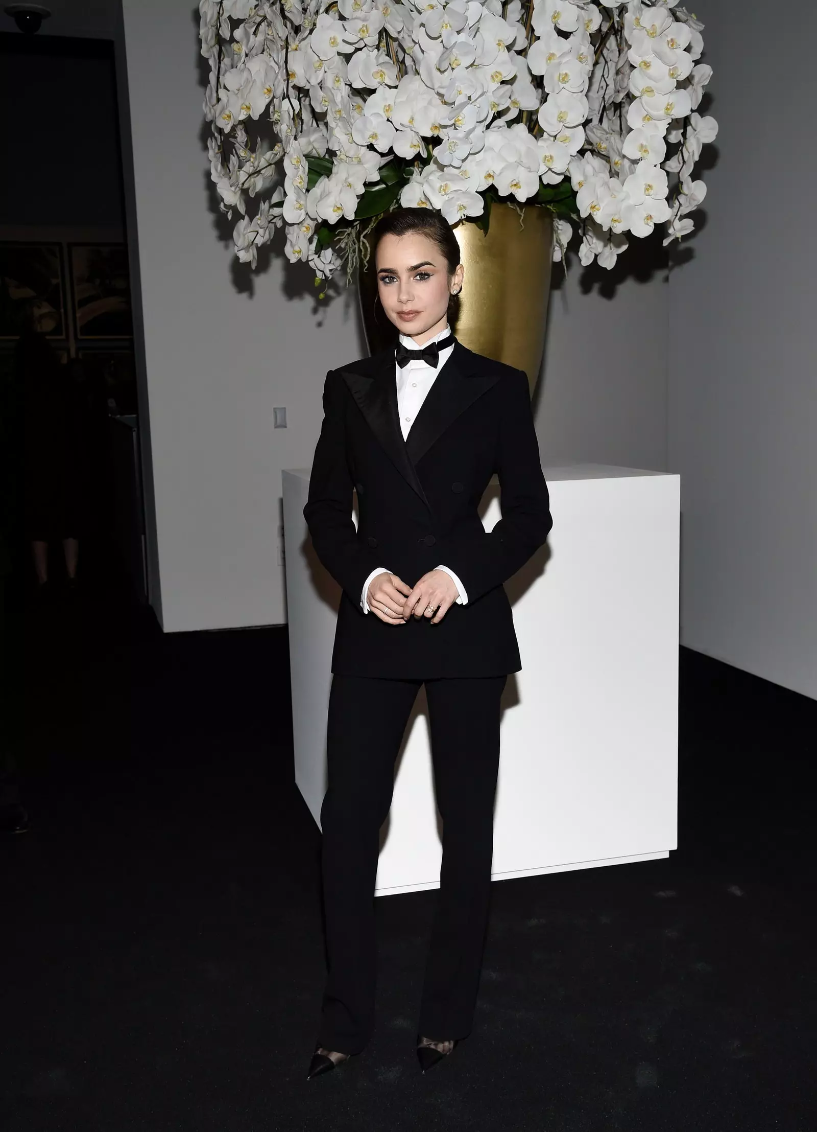 Lily Collins mewn tuxedo a thei bwa