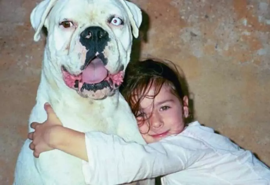 Childhood family snapshot of her with her pet