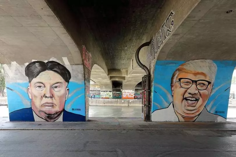 Múrmhaisiú graifítí ‘Hairswap’ i Vín. Kim Jong Un agus an tUachtarán Donald Trump