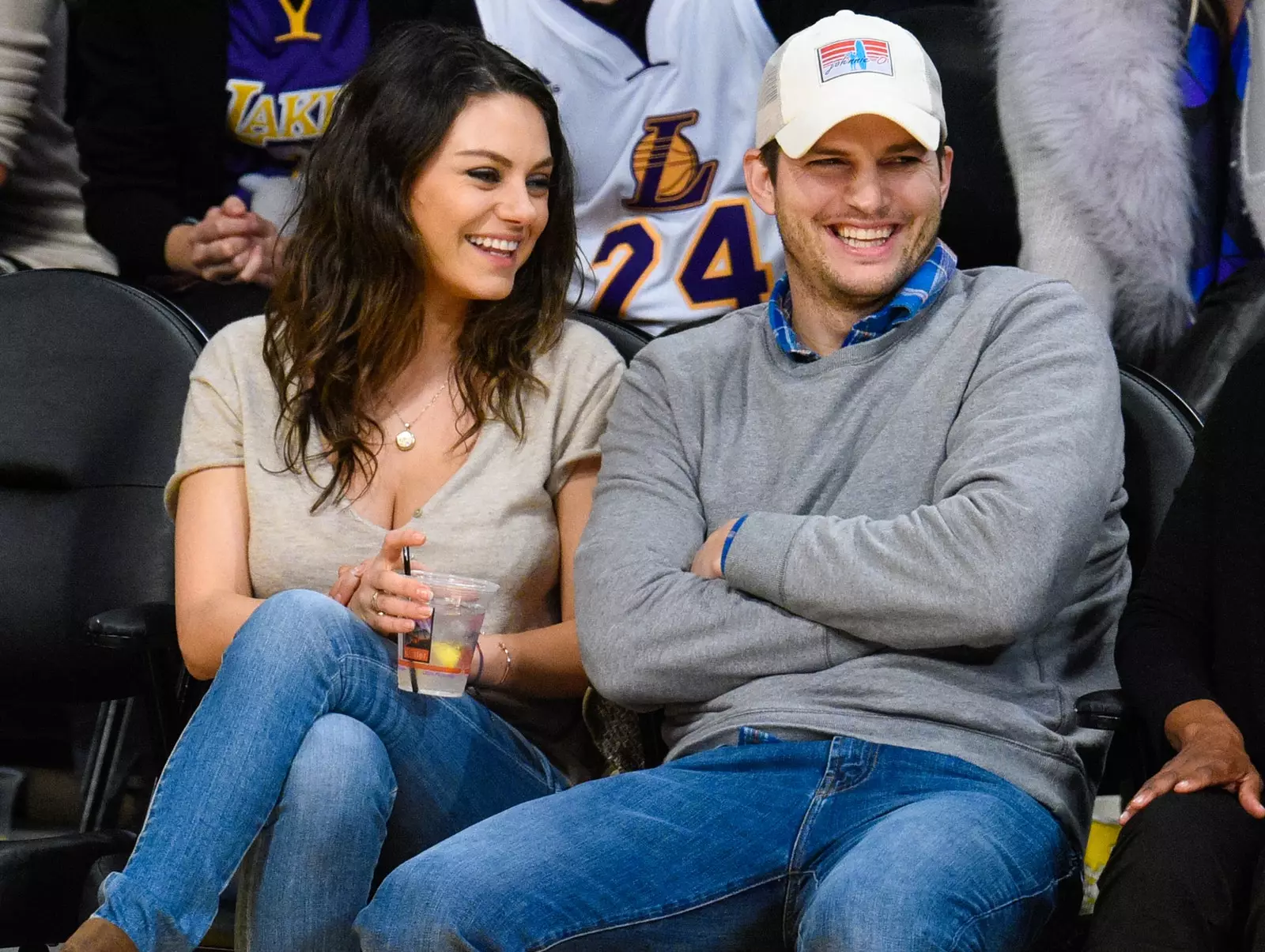 Mila Kunis እና Ashton Kutcher የቤዝቦል ጨዋታ እየተመለከቱ።