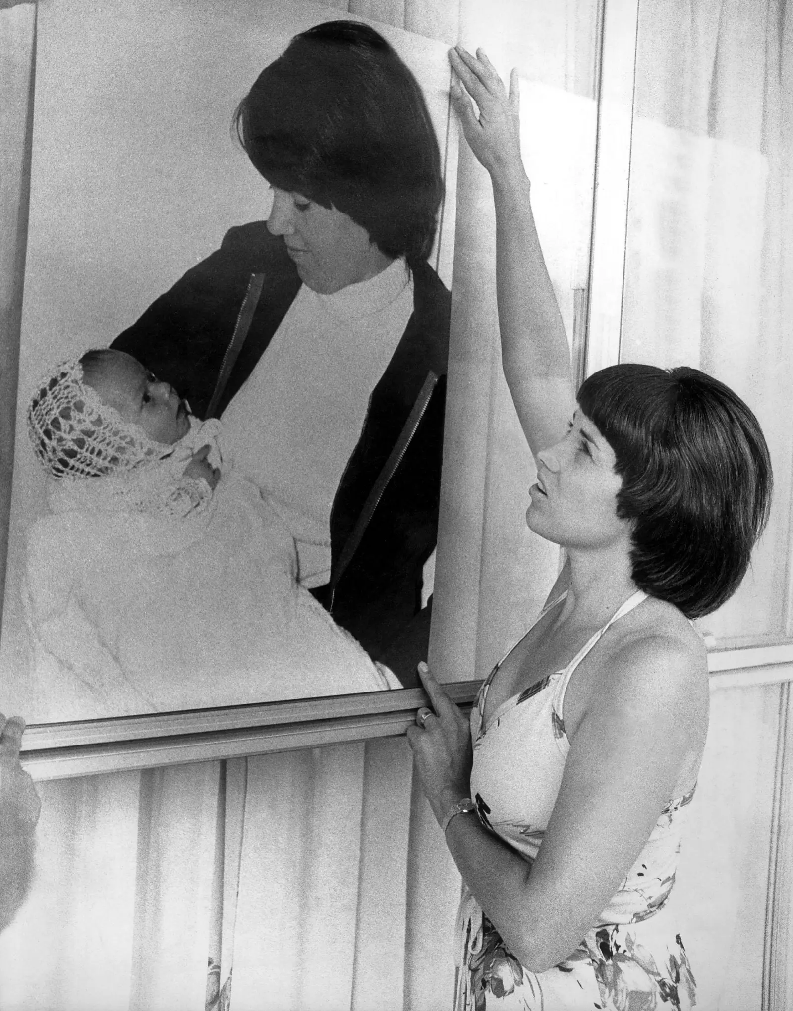 リンディは娘のアザリアの肖像画の前でポーズをとる