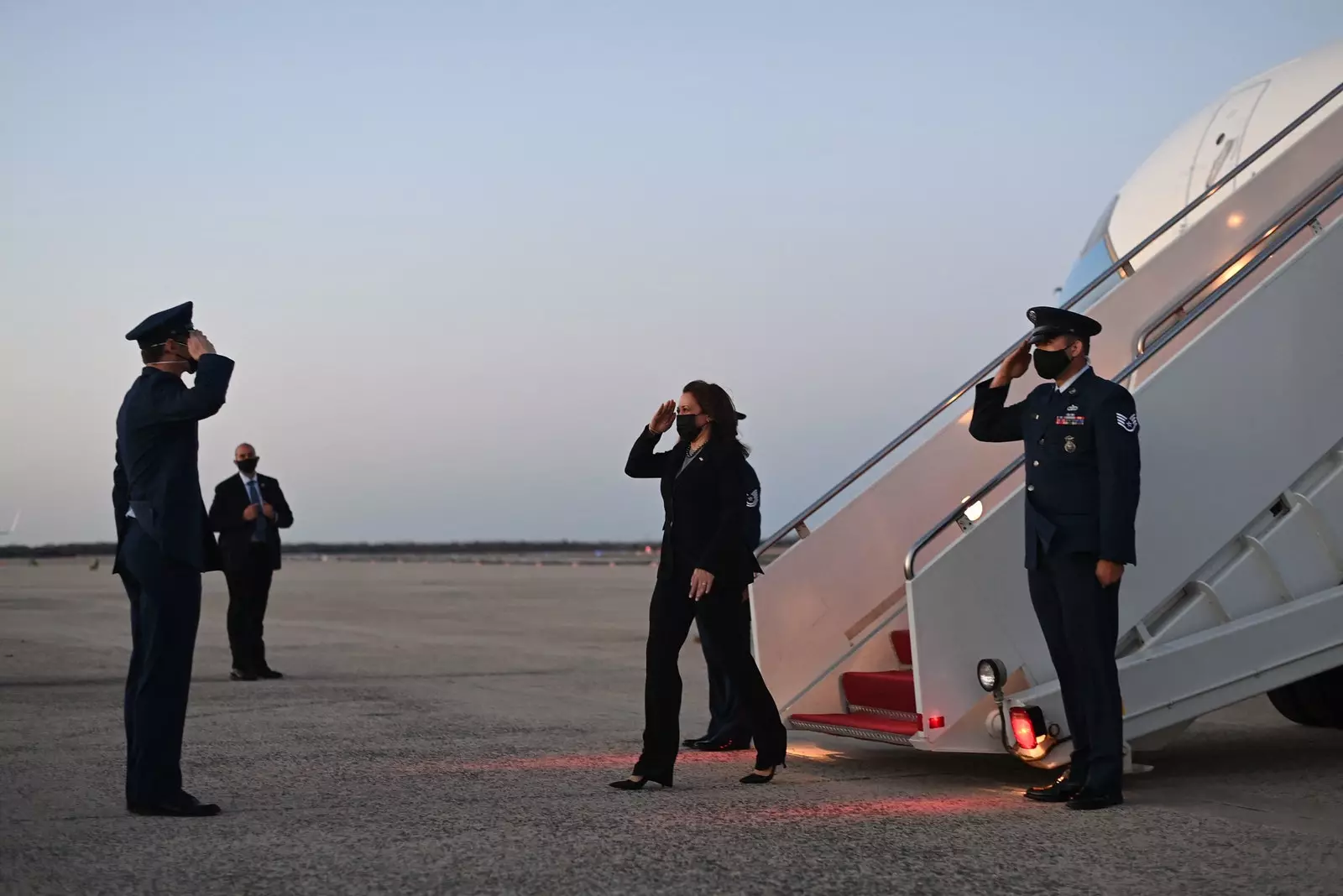 Kamala Herisa sveic virsniekus, izkāpjot no Air Force Two.