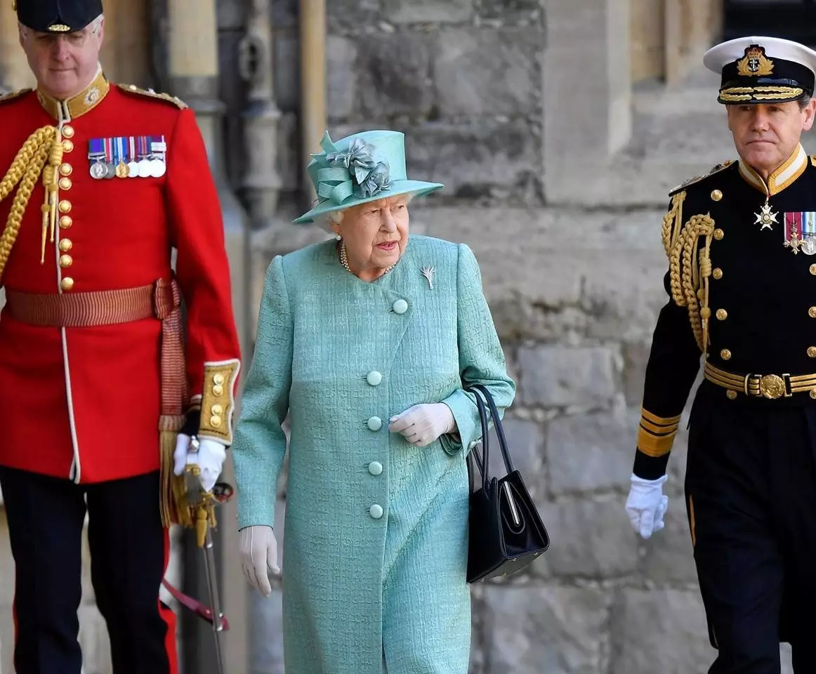 Elizabeth II com dois oficiais do palácio.
