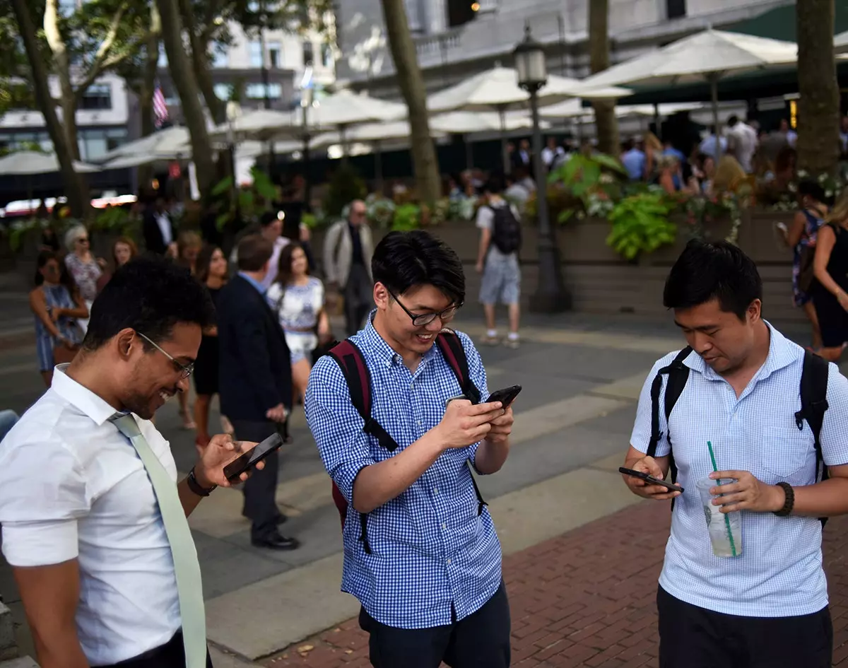 Three Pokémon Go players in Bryant Park New York.