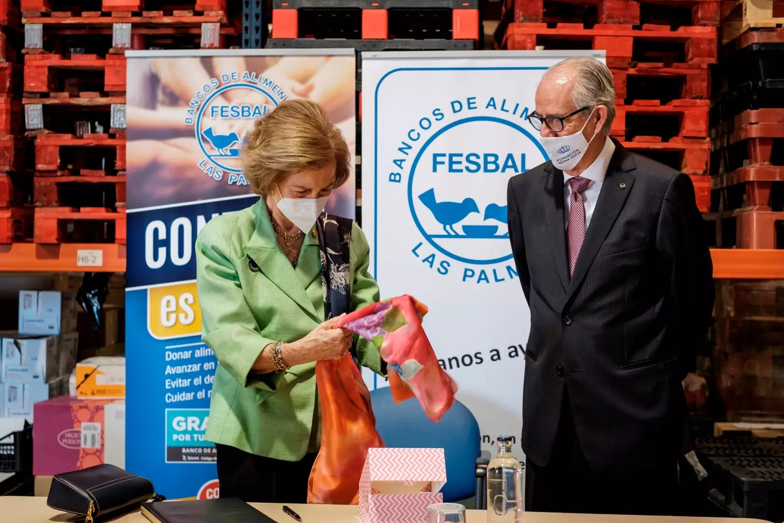 La reine Sofía reçoit un foulard en soie lors de sa visite à la banque alimentaire de Las Palmas.