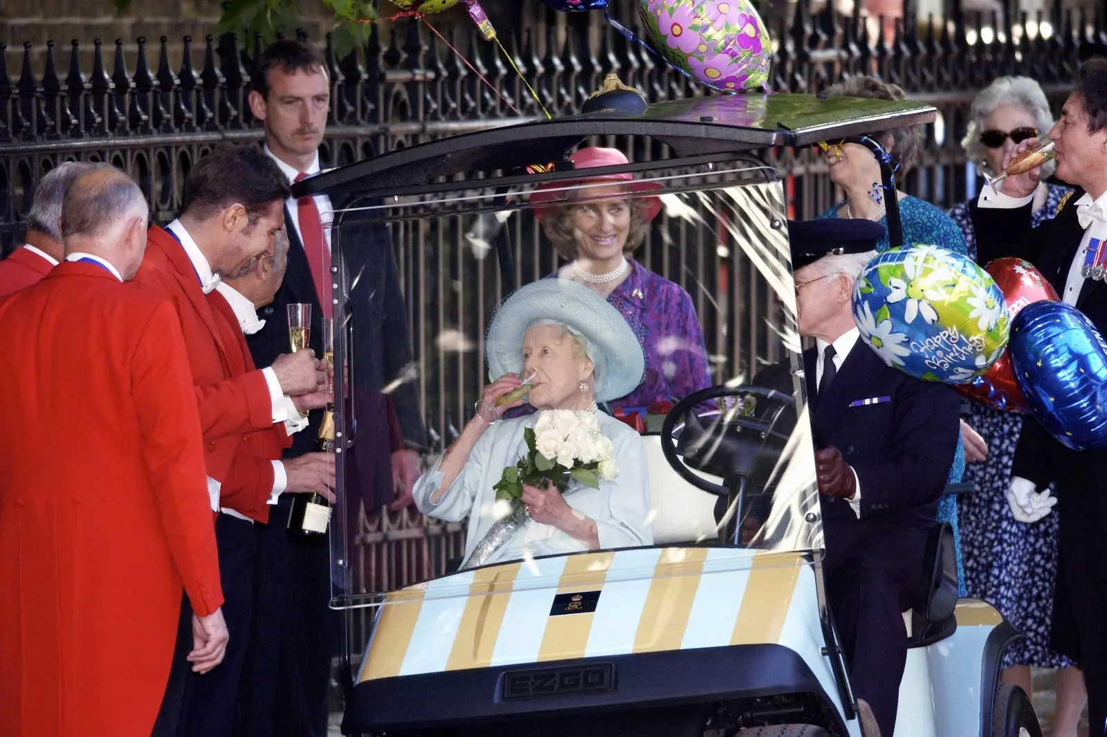 La regina madre beve champagne circondata da alcuni dei suoi dipendenti per celebrare il suo 101esimo compleanno