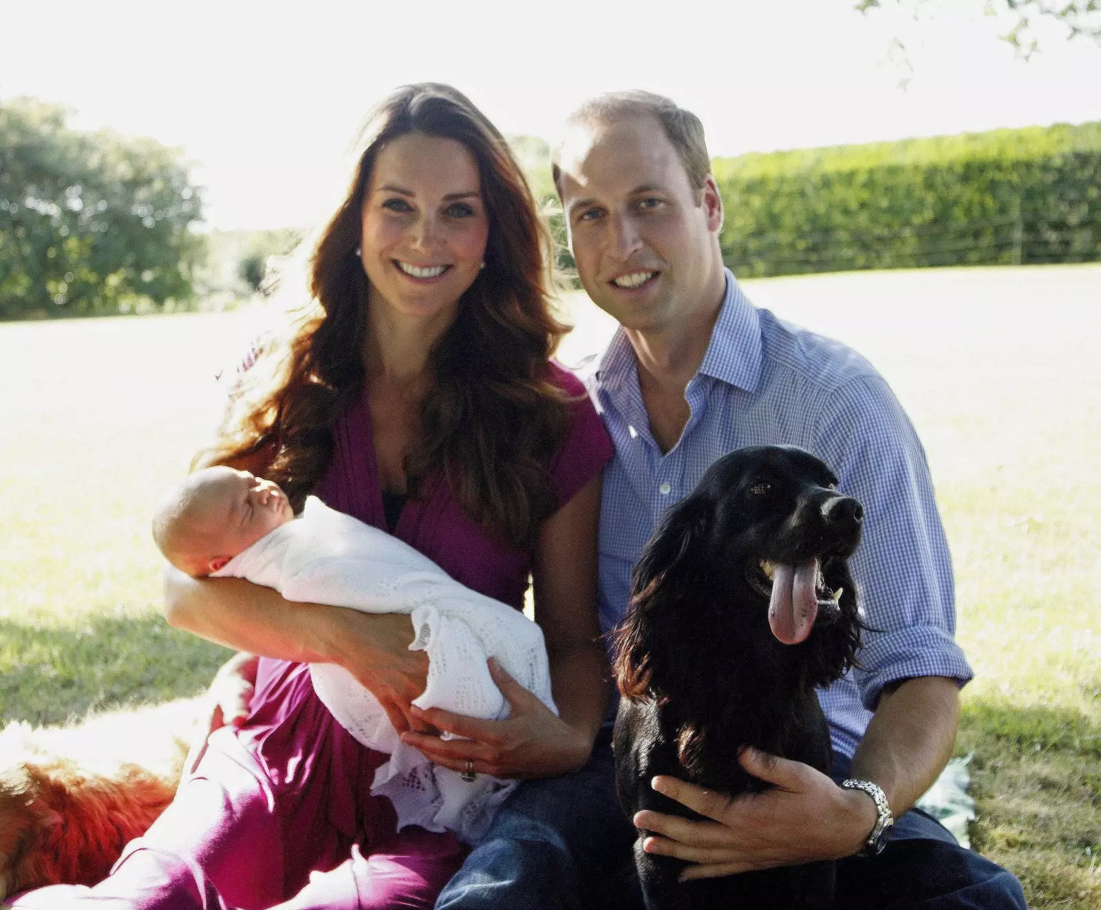 Il principe William e Kate Middleton con il piccolo George in braccio e Lupo il suo cocker spaniel nel 2013.