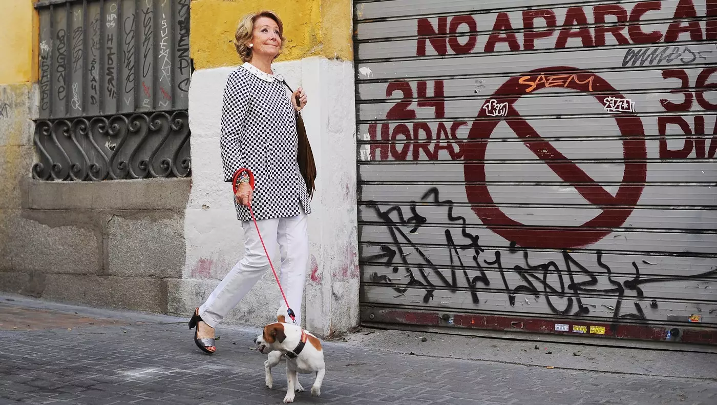 Esperanza Aguirre promenante sian hundon Pecas tra la stratoj de Malasaña.