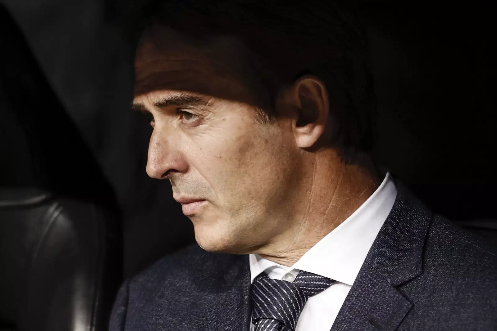 Julen Lopetegui sitting on the bench during a match at the Santiago Bernabeu Stadium.