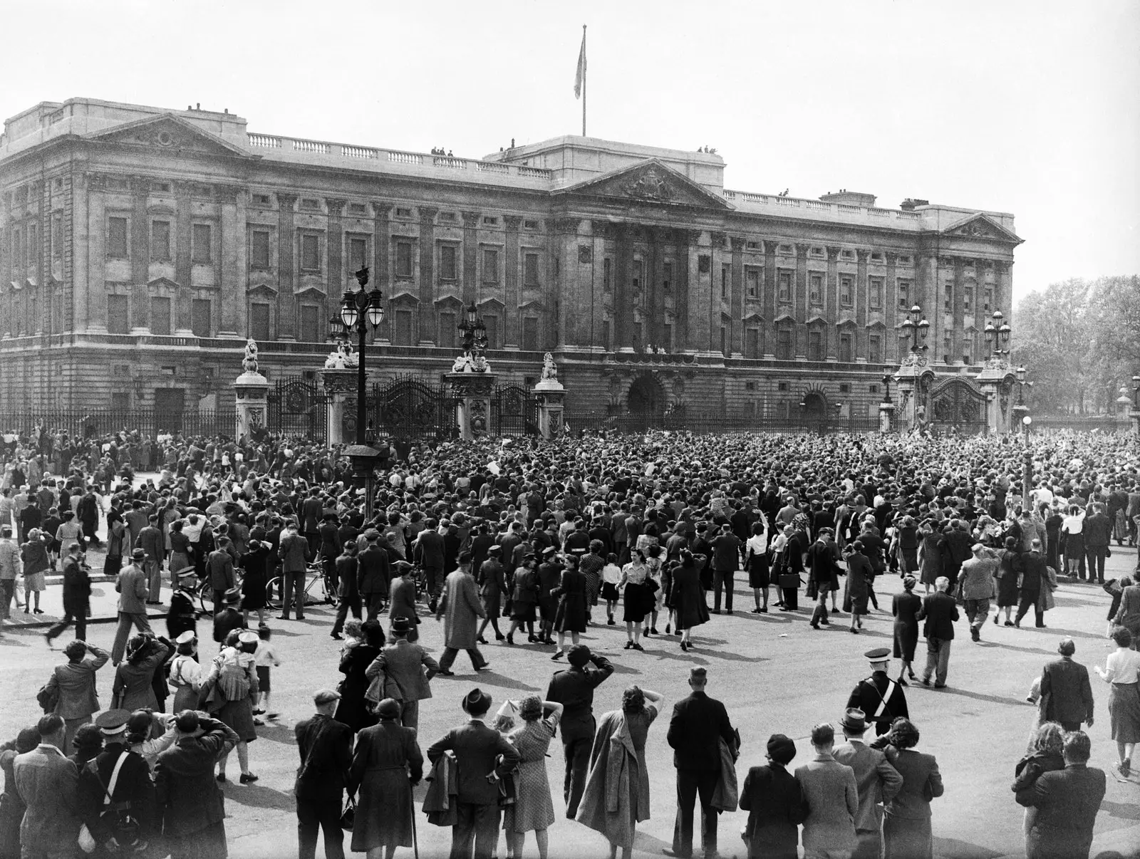 E Publikum feiert d'Enn vum Zweete Weltkrich ausserhalb vum Buckingham Palace.